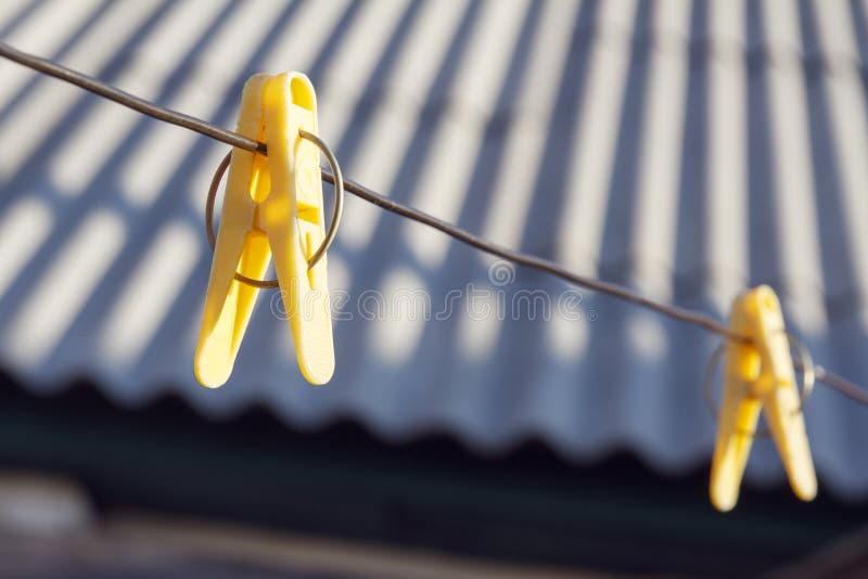 On the Metal Wire Hang an Old Yellow Plastic Clothes Pin. Stock Photo ...