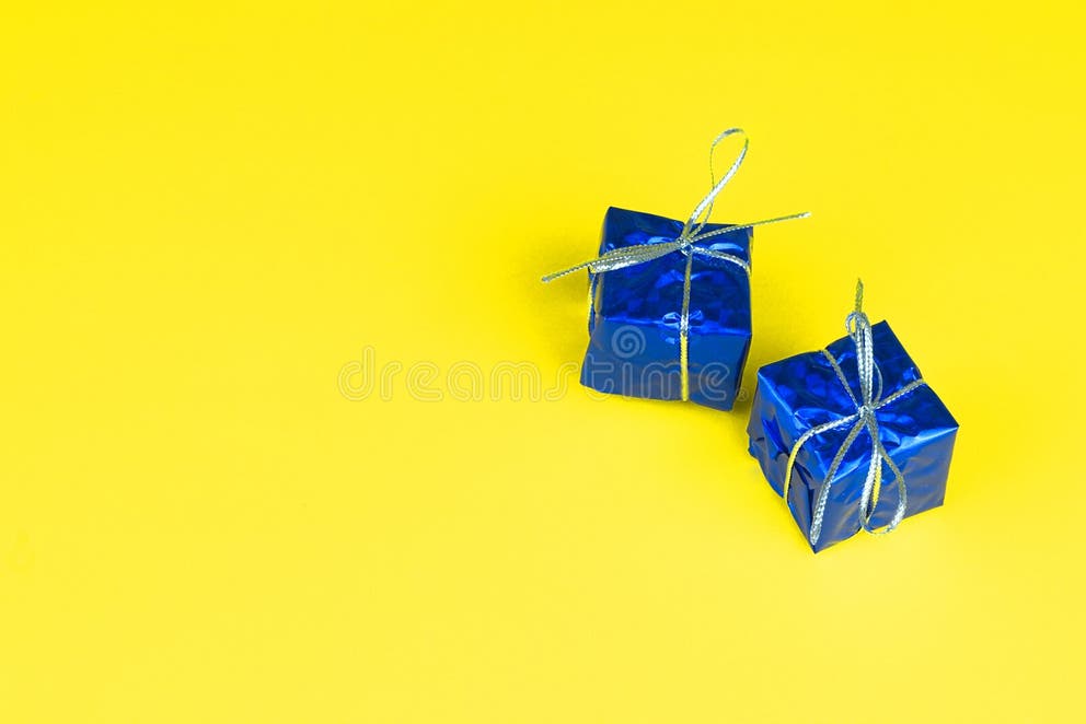 Metallic Blue Present with Silver Strings on a Yellow Background Stock ...