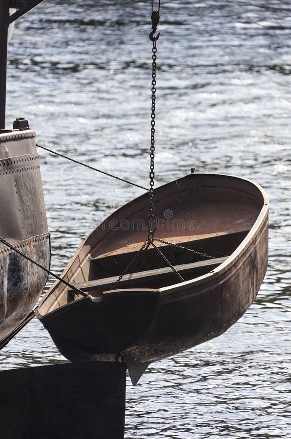 Metallic Boat Hangs Over Water on Steel Chain Overboard Stock Image ...