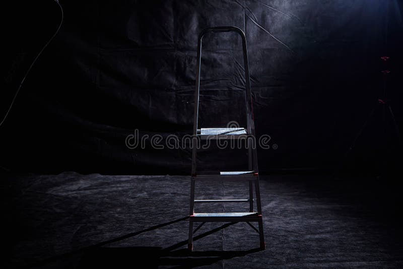 Metallic Construction Ladder in a Black Room with a Dark Background ...