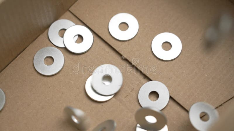 Metallic Fastener Washers Falling into a Cardboard Box in Slow Motion ...