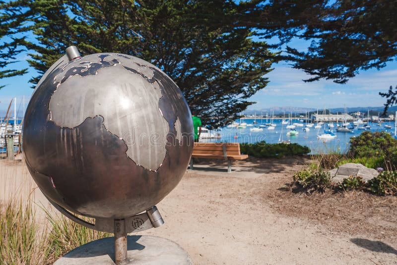 Metallic Globe Sculpture with Harbor View, Coastal Park Setting ...