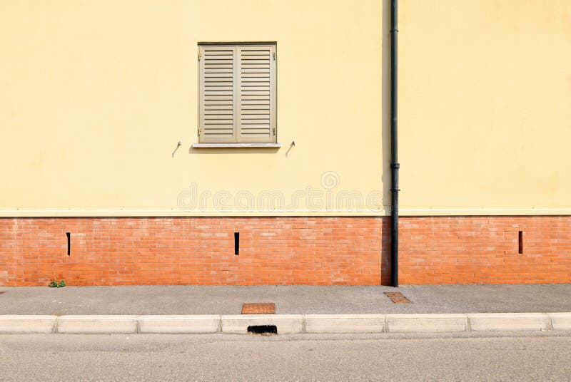 Metallic Window Shutter on a Red and Yellow Facade. Concrete Sidewalk ...