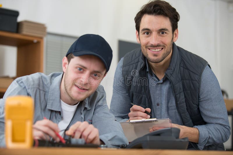 Metalworker with Apprentice in Workshop Stock Image - Image of holding ...