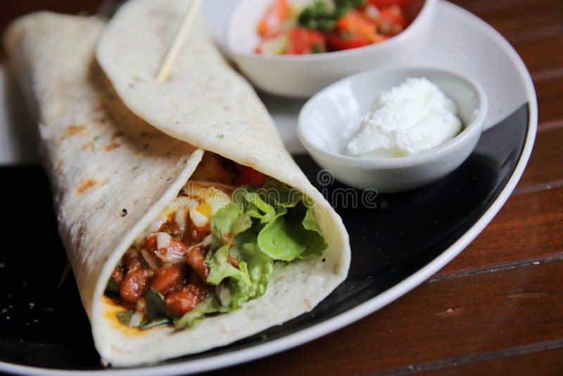 Mexican Burritos on a Plate with Tomato Salad Stock Photo - Image of ...