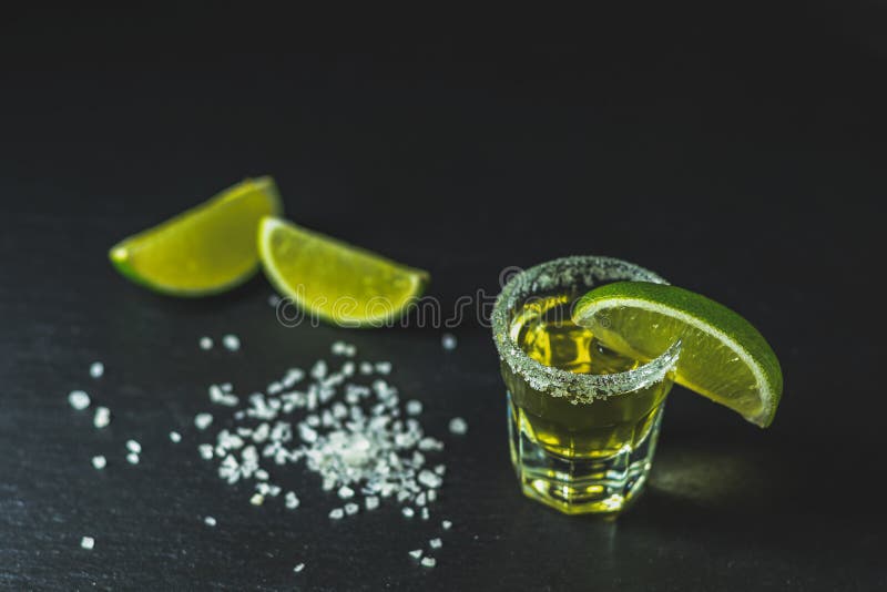 Mexican Gold Tequila Shot with Lime and Salt on Black Stone Table ...