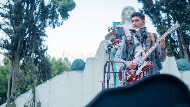 Man Playing Several Instruments at Once Performs in Front of a Fountain ...
