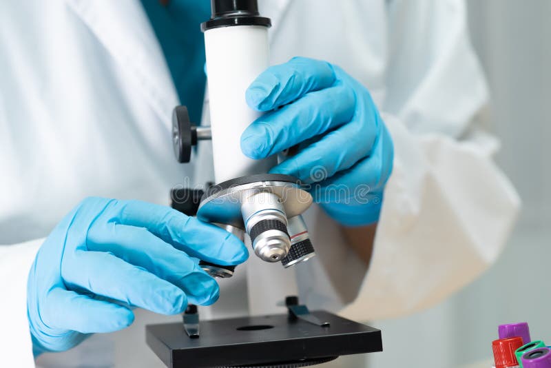 Microbiologist Working Research with a Microscope in Laboratory. Stock ...
