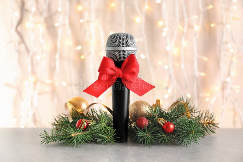 Microphone with Red Bow and Fir Branches Against Blurred Lightst ...