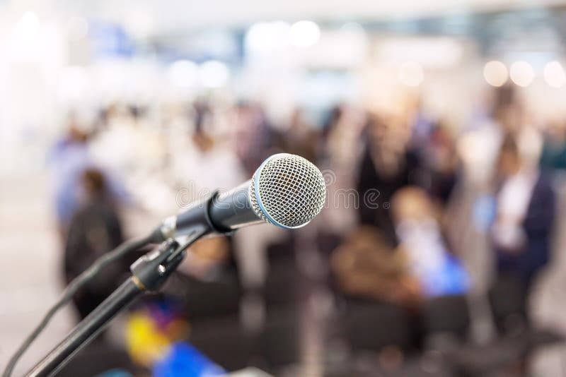 Microphone in Focus Against Blurred Audience. News Conference. Stock ...