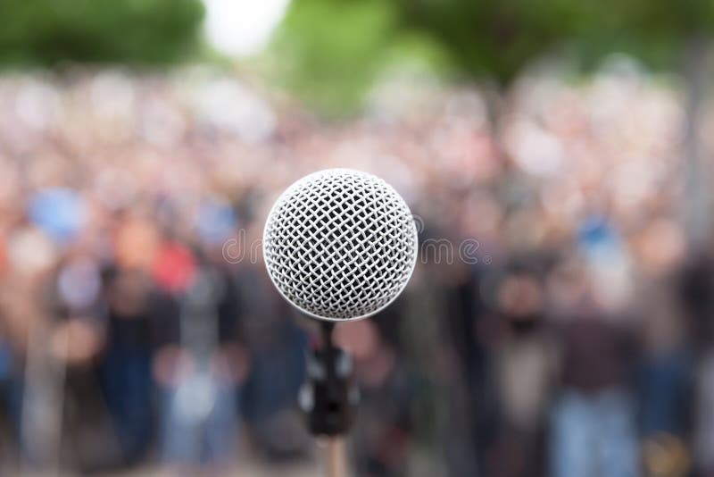 Microphone in Focus Against Blurred Crowd. Political Rally. Stock Photo ...