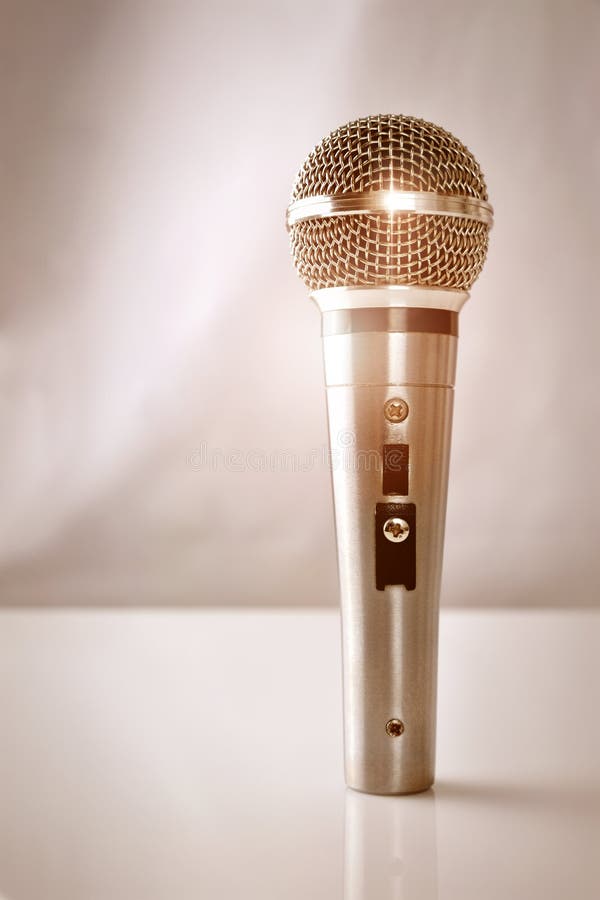 Microphone with Golden Reflections Standing on a White Glass Stock ...
