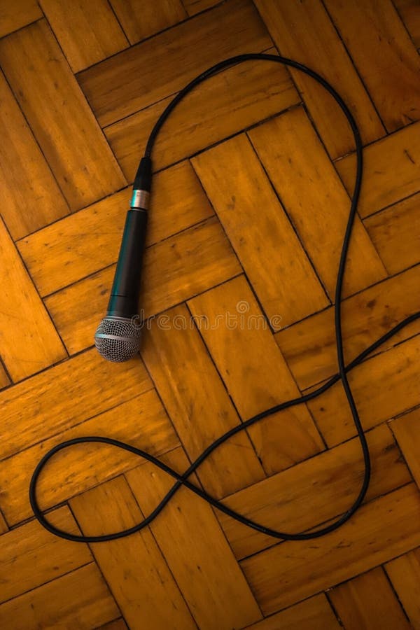 Microphone with a Long Cord Wrapped Around it, on a Wooden Floor Stock ...