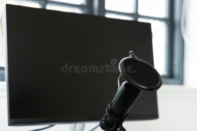 Microphone with Pop Filter in Front of Blank Computer Monitor at Home ...