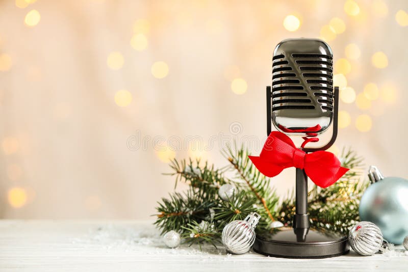 Microphone with Red Bow and Decorations on White Table Against Blurred ...