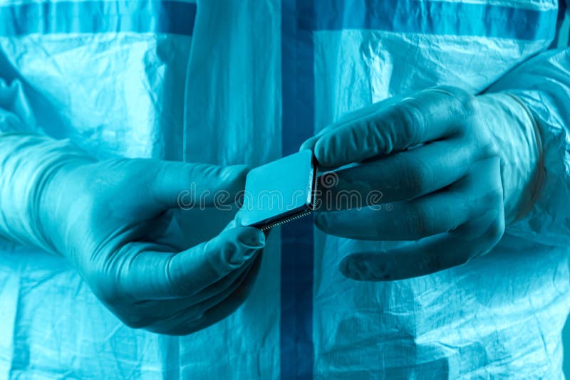 Microprocessor in Hands in Latex Gloves in a Sterile Suit Close-up. the ...
