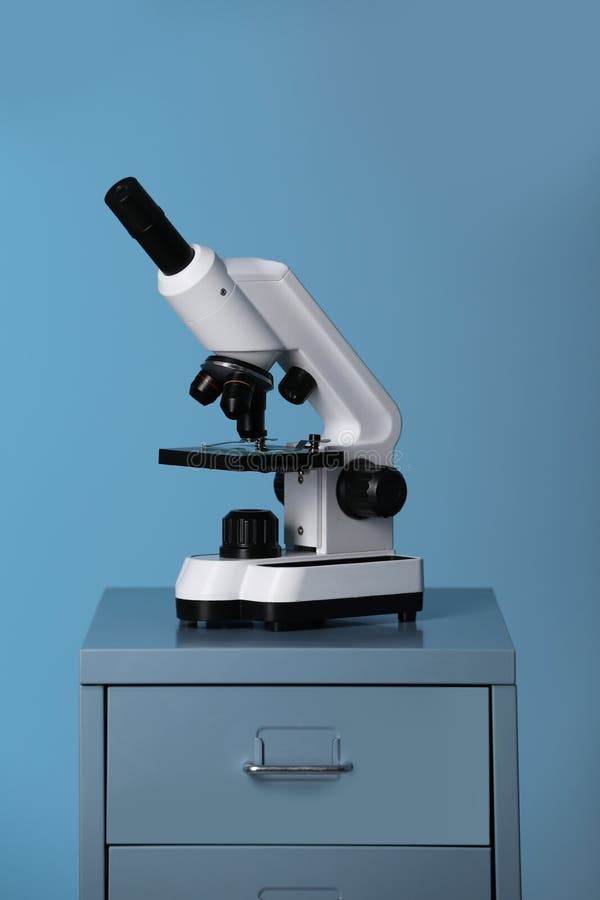 Microscope on Laboratory Cabinet Against Blue Background Stock Image ...