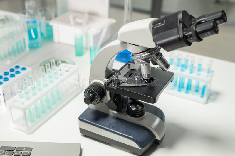 Microscope Surrounded by Groups of Flasks with Blue Liquid Standing on ...