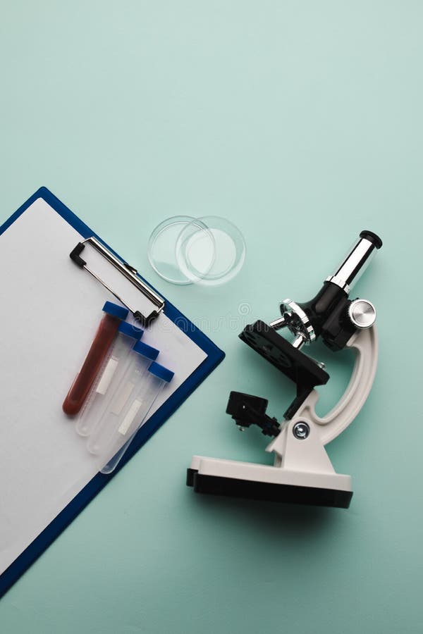 Microscope, test tubes and watch glass on a blue background. Laboratory ...