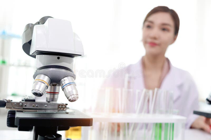 Microscopes in Laboratory with Blurred Background of Female Scientist ...