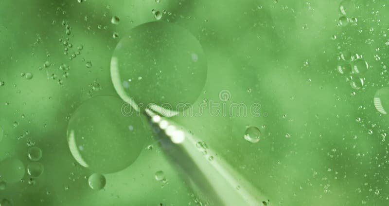 Microscopic Close-up of a Droplet of Green Liquid Chemical Solution in ...