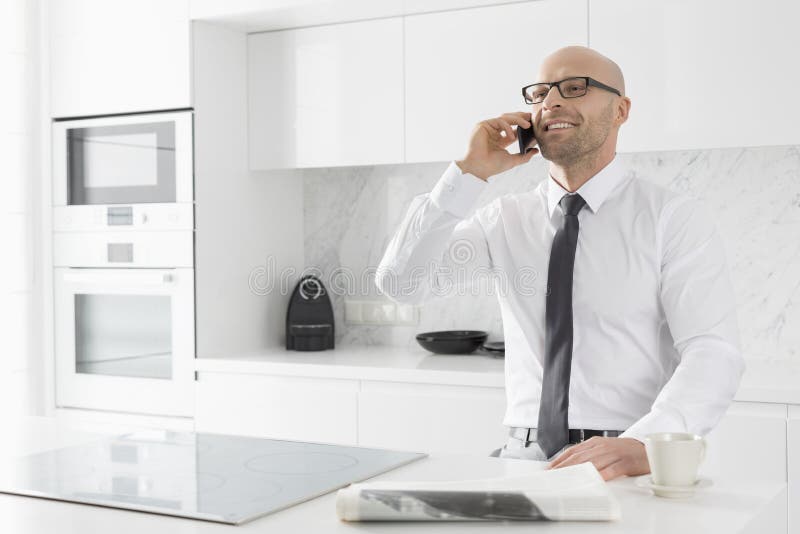 Mid Adult Businessman on Call at Kitchen Counter Stock Image - Image of ...