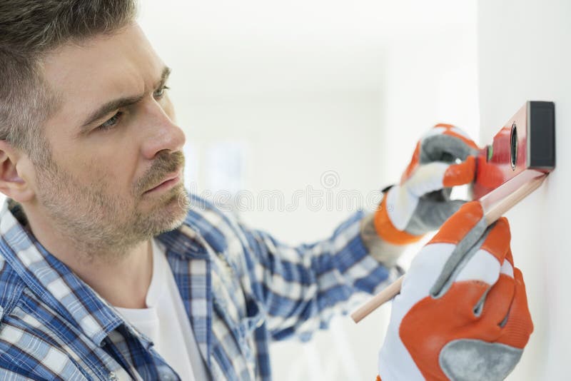 Mid-adult Man Marking on Wall with Level Stock Photo - Image of devices ...