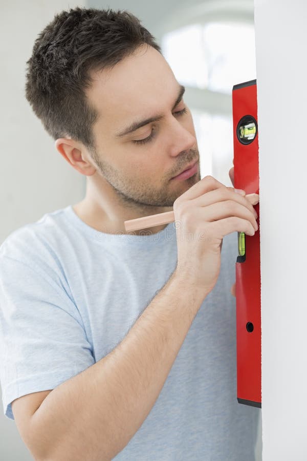 Mid-adult Man Marking on Wall with Level Stock Image - Image of holding ...