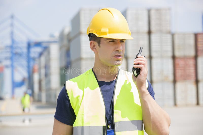 Mid Adult Man Using Walkie-talkie in Shipping Yard Stock Image - Image ...