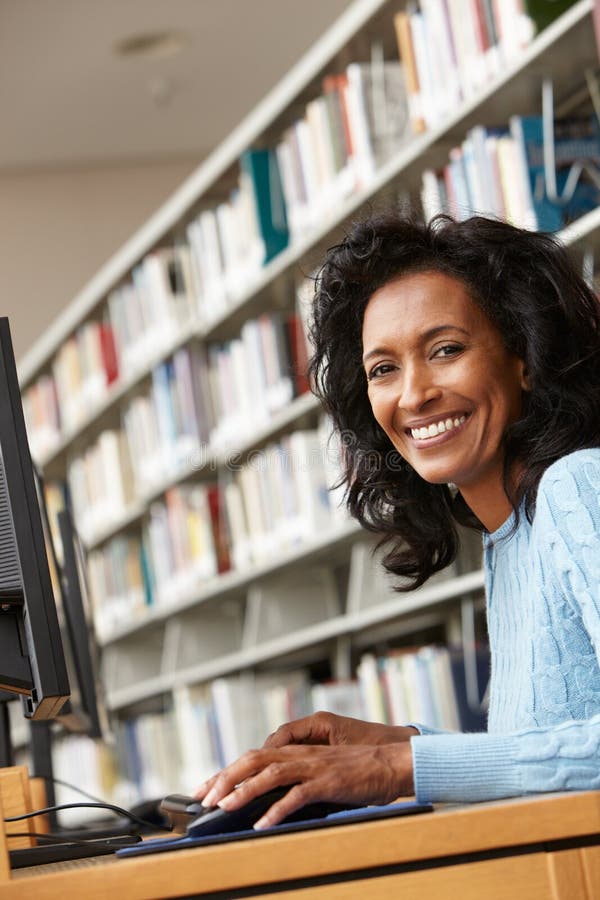 Mid Age Woman Working on Computer in Library Stock Photo - Image of ...