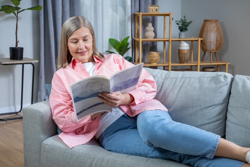 Mid Aged Woman Reading a Newspaper at Home and Looking Involved Stock ...