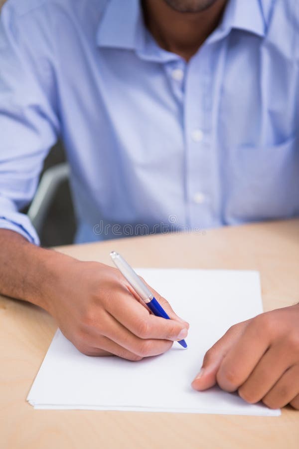 Mid Section of Businessman Writing Document at Desk Stock Image - Image ...