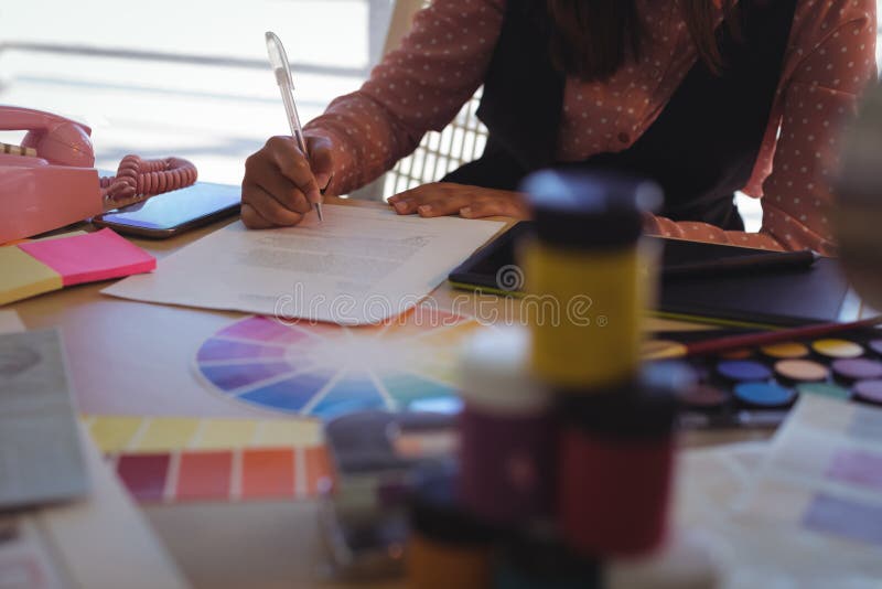 Mid Section of Businesswoman Writing on Paper at Office Desk Stock ...