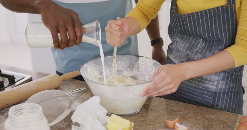 Mid Section of Diverse Couple Wearing Apron and Baking in Kitchen Stock ...