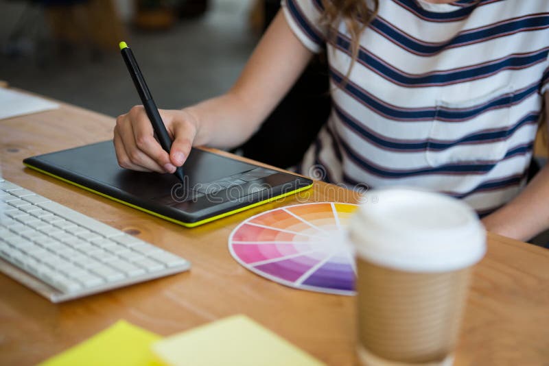 Mid Section of Female Graphic Designer Using Graphics Tablet at Desk ...