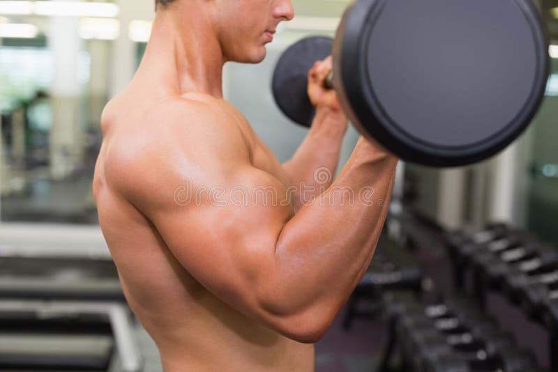 Mid Section Of A Shirtless Muscular Man Lifting Barbell Stock Image