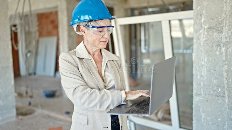 Middle Age Blonde Woman Architect Using Laptop with Relaxed Expression ...