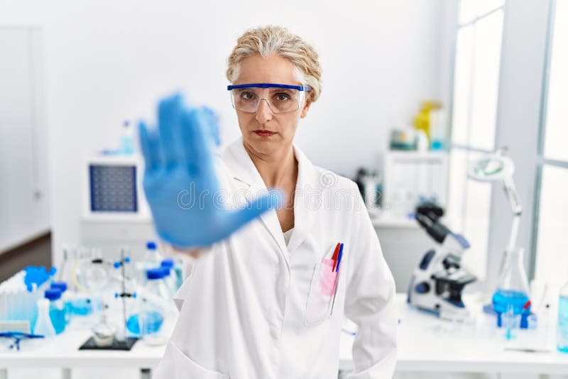 Middle Age Blonde Woman Working at Scientist Laboratory Doing Stop Sing ...