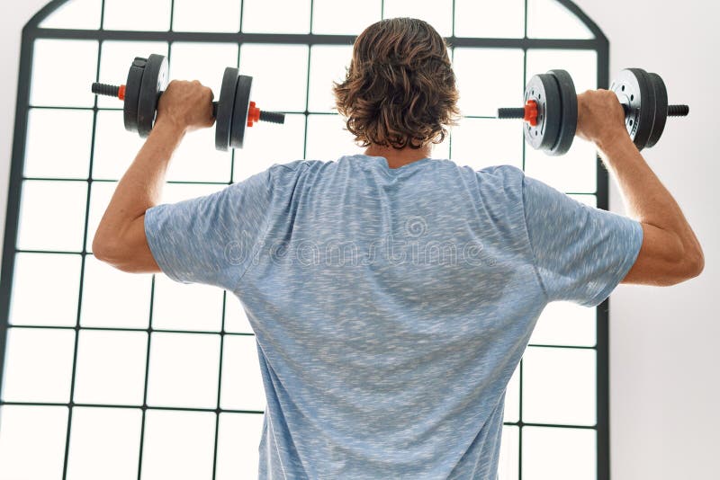 Middle Age Caucasian Man on Back View Training Using Dumbbells at Sport ...
