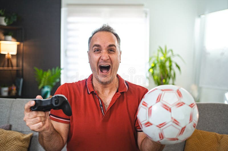 Middle Age Caucasian Man Playing Soccer Video Game at Home Stock Image ...