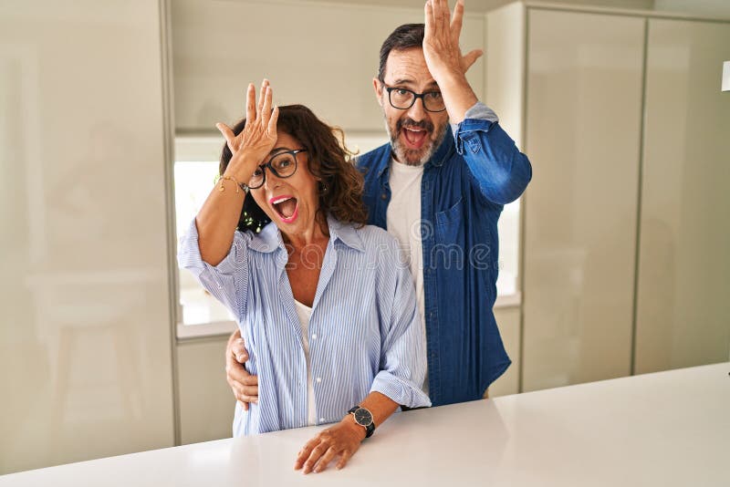 Middle Age Couple Standing Together Surprised with Hand on Head for Mistake, Remember Error ...
