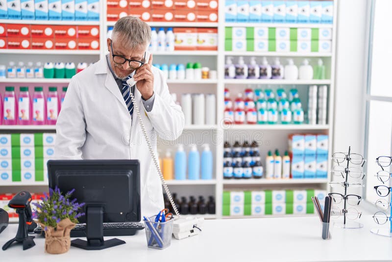 Middle Age Grey-haired Man Pharmacist Talking on Telephone Using ...