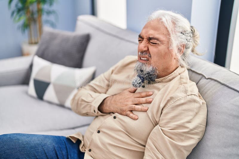 Middle Age Grey-haired Man Sitting on Sofa Suffering Heart Attack at ...