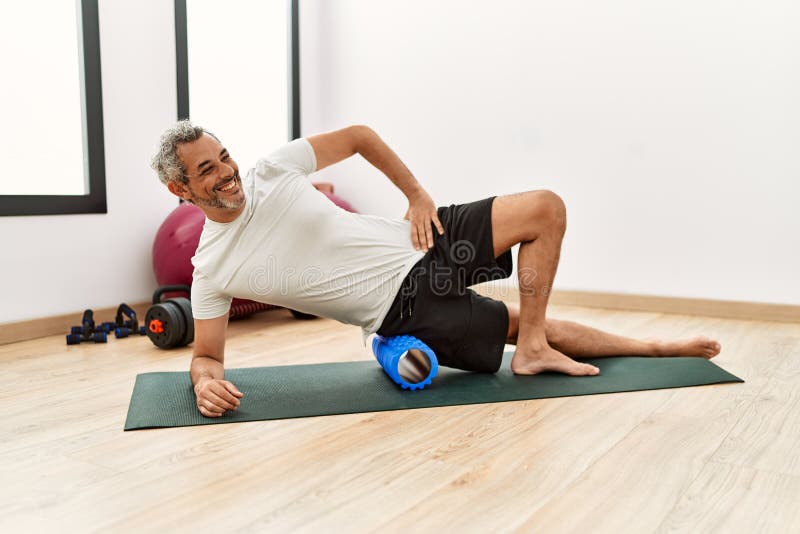Middle Age Grey-haired Man Using Foam Roller Stretching at Sport Center ...