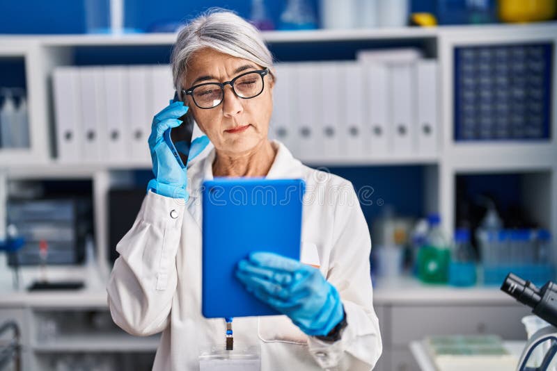 Middle Age Grey-haired Woman Scientist Using Touchpad Talking on ...