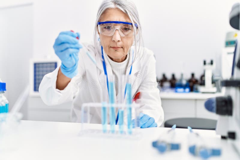 Middle Age Grey-haired Woman Wearing Scientist Uniform Using Pipette at ...