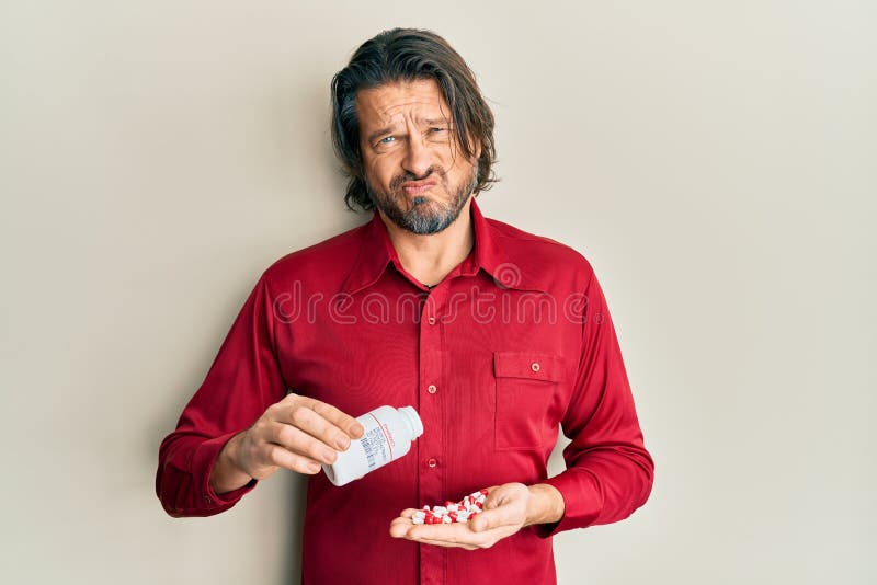 Middle Age Handsome Man Taking Pills Depressed and Worry for Distress ...