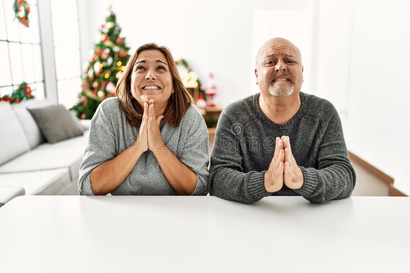 Middle Age Hispanic Couple Sitting on the Table by Christmas Tree ...