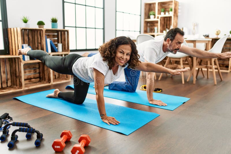 Middle Age Hispanic Couple Smiling Happy Stretching on the Floor at ...