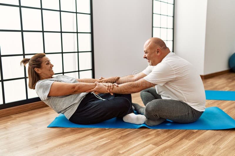 Middle Age Hispanic Couple Training Abs Exercise at Sport Center Stock ...